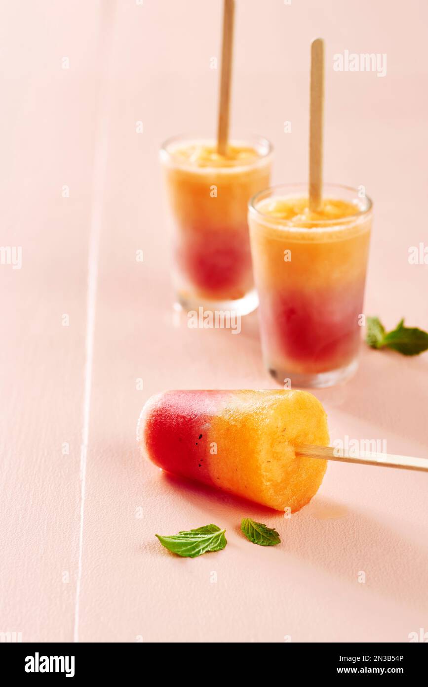 Homemade fruit ice pops with mint on a peach background Stock Photo - Alamy