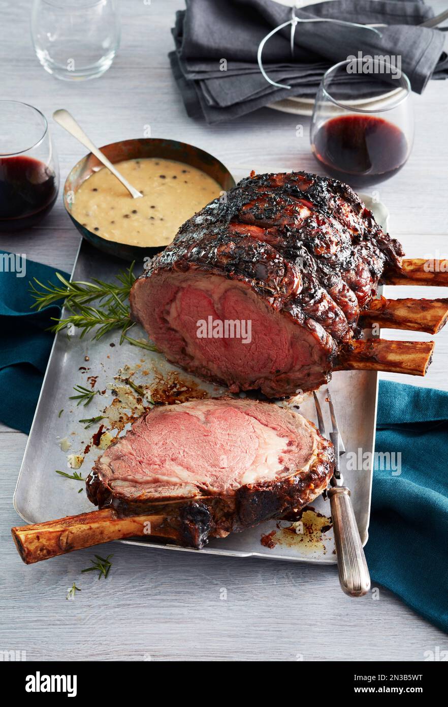 Standing rib roast with bearnaise sauce and glasses of red wine Stock ...
