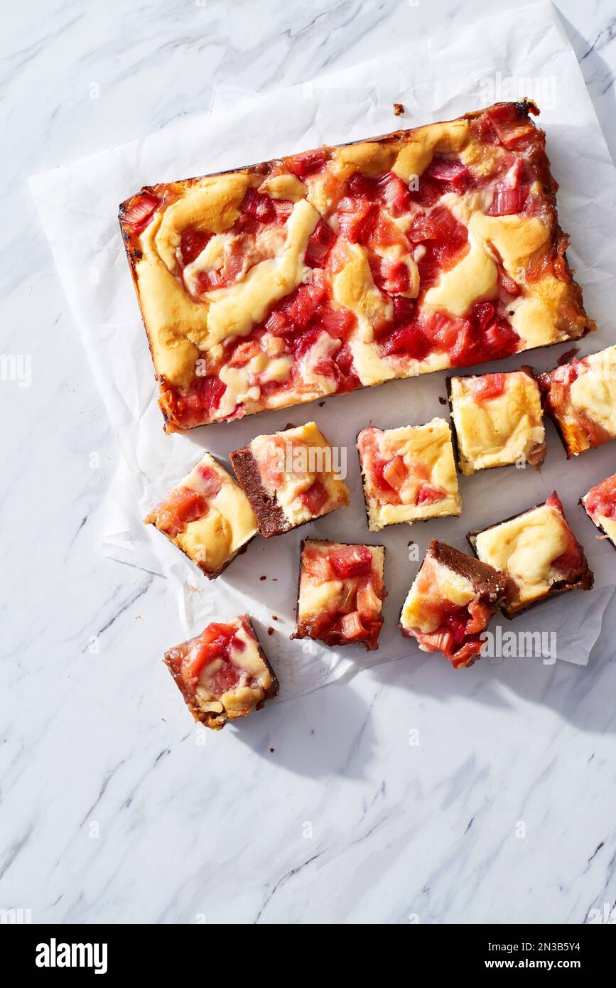 Rhubarb squares with fudge and cream cheese layers cut into pieces on ...
