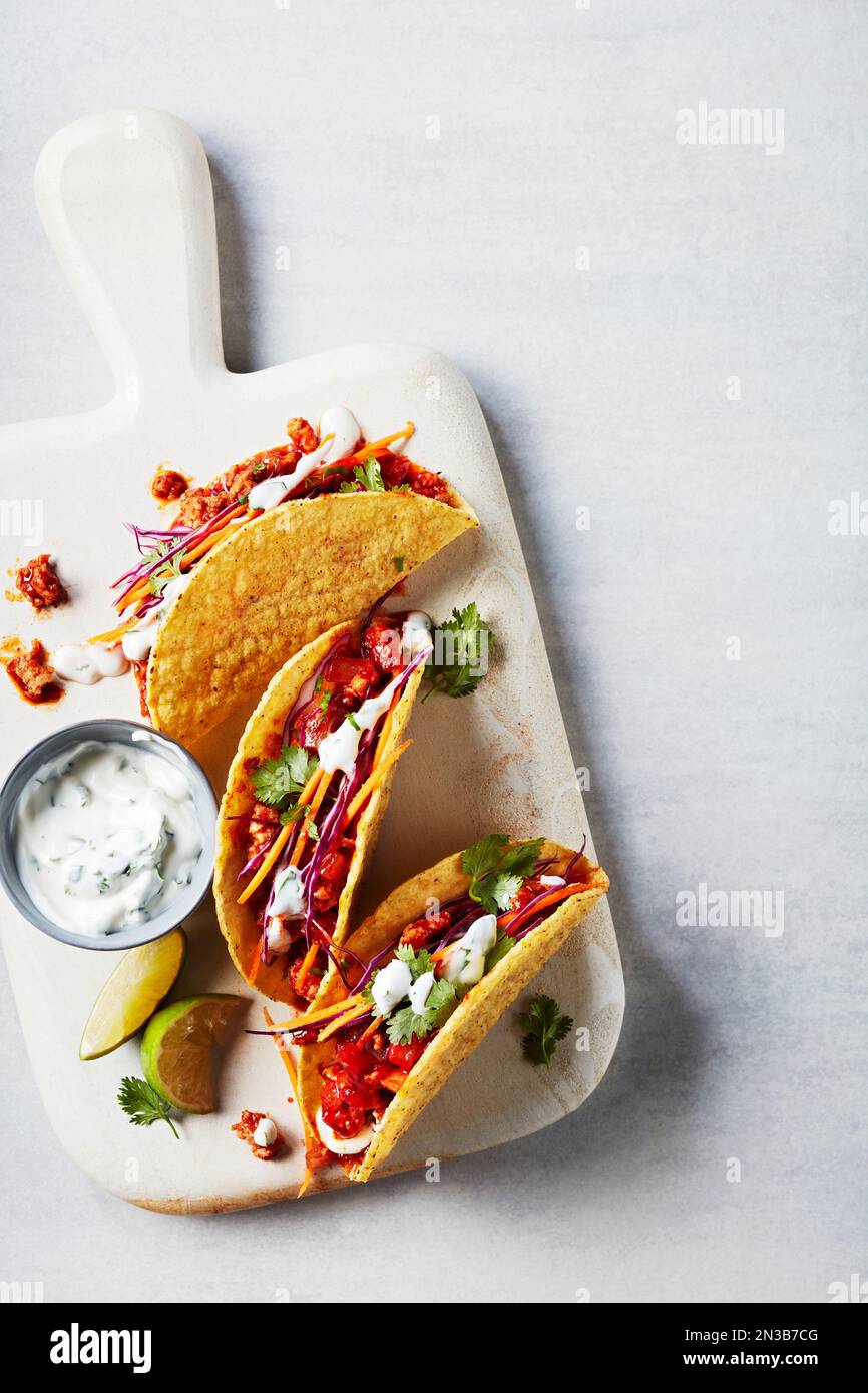 Saucy chicken tacos on a wite marble cutting board Stock Photo - Alamy