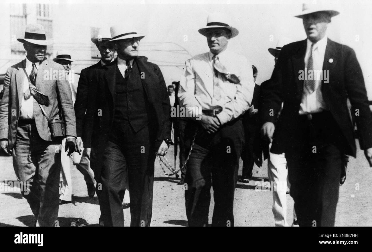 Albert Bates, center, coatless, surrounded by armed guards, arrives in ...