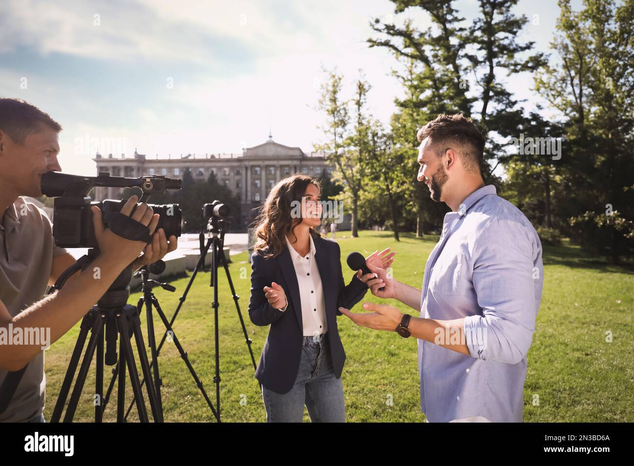 Professional journalist and operator with video camera taking interview ...
