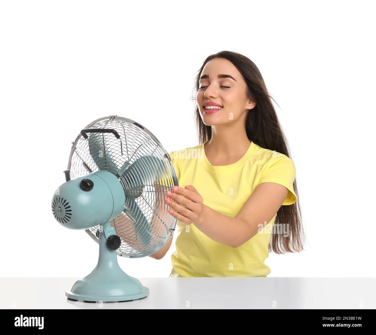 Woman enjoying air flow from fan on white background. Summer heat Stock ...