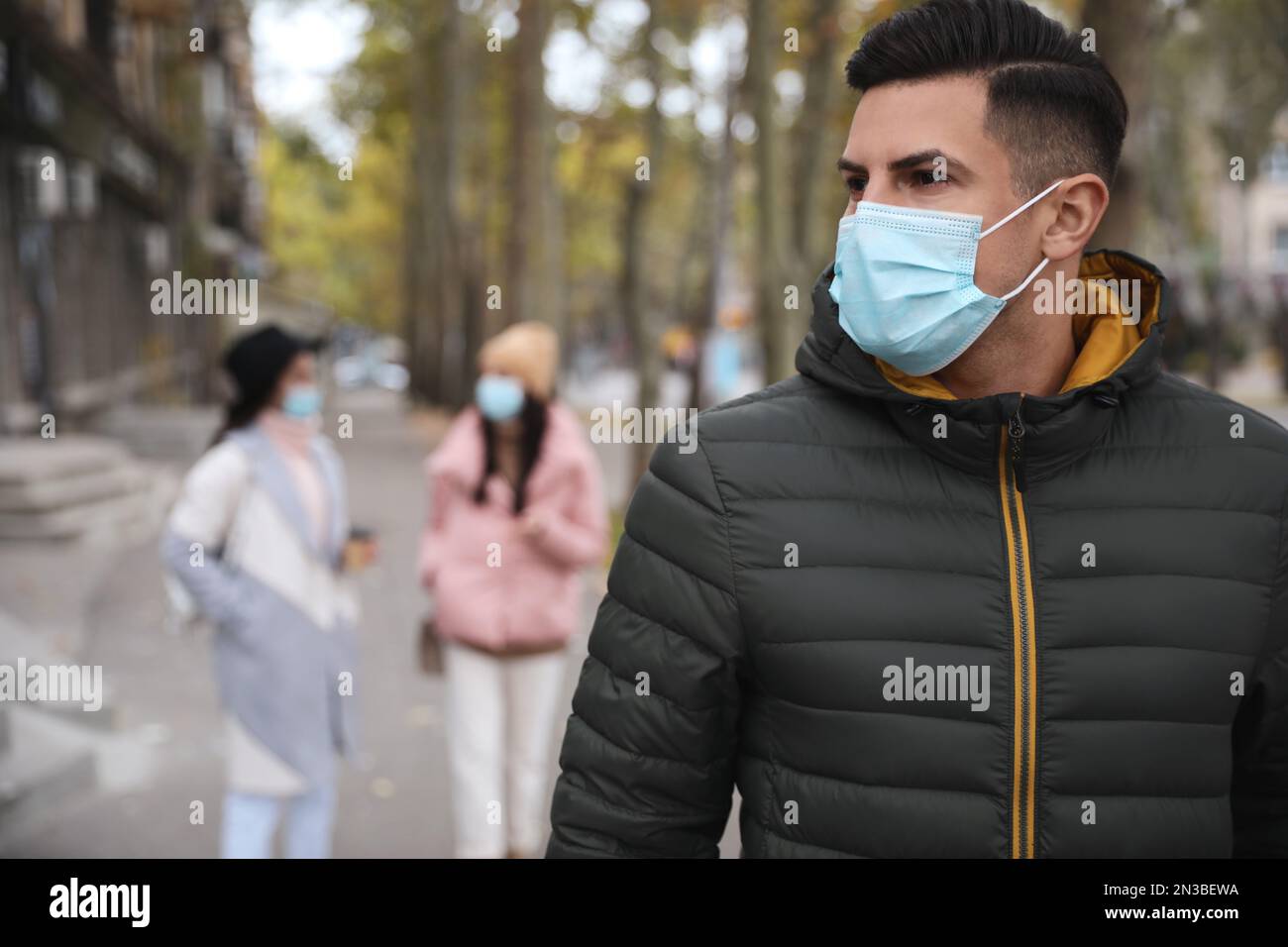 Man in medical face mask walking outdoors. Personal protection during ...