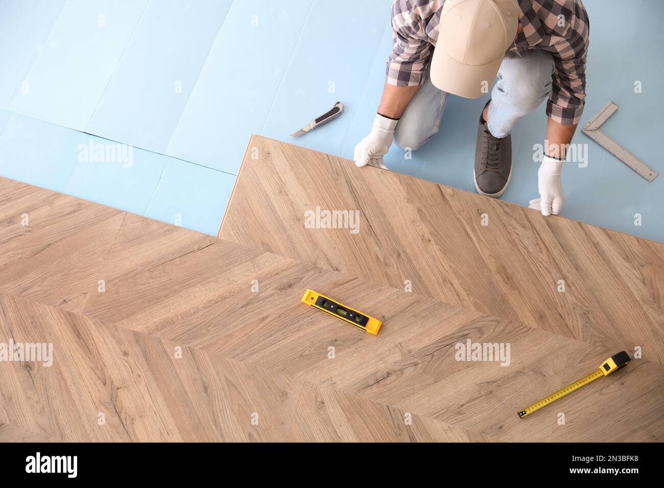 Worker installing laminated wooden floor indoors, above view Stock ...
