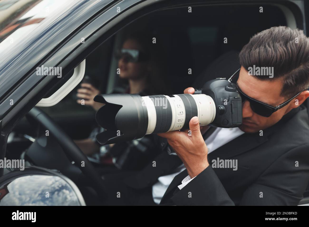 Private detectives with modern camera spying from car Stock Photo - Alamy