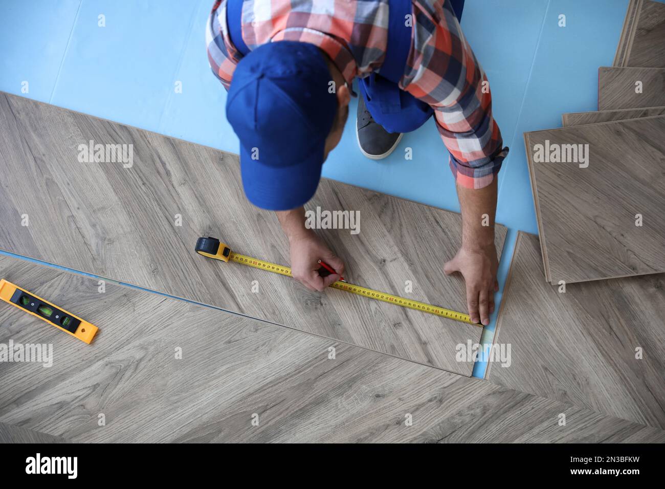 Worker installing laminated wooden floor indoors, above view Stock ...