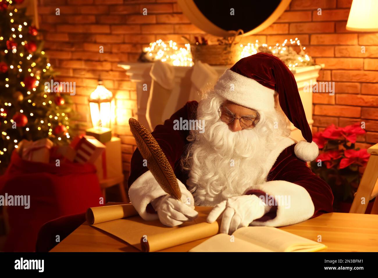 Santa Claus writing letter at table indoors Stock Photo - Alamy