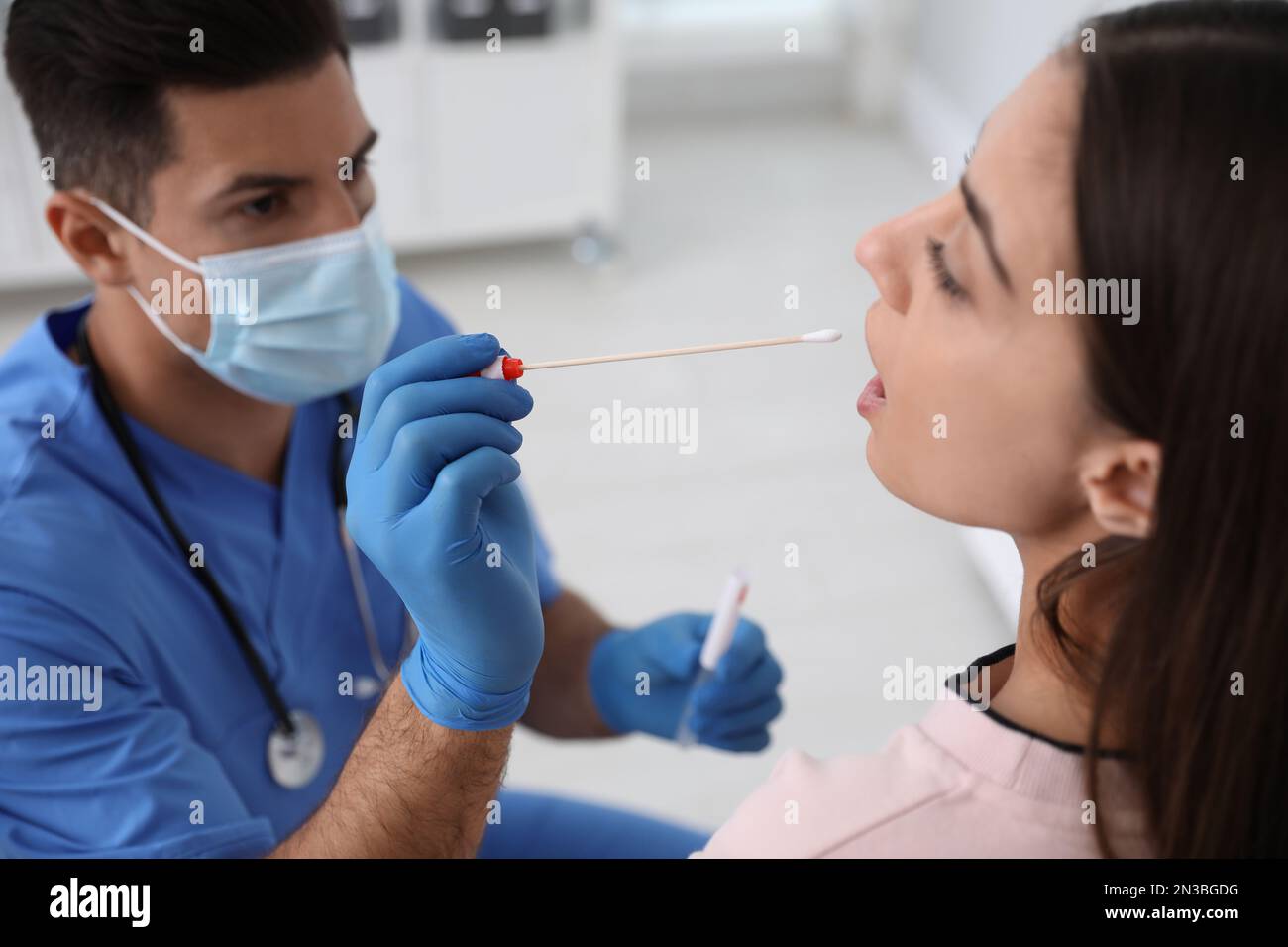 Doctor taking sample for DNA test from woman in clinic Stock Photo - Alamy