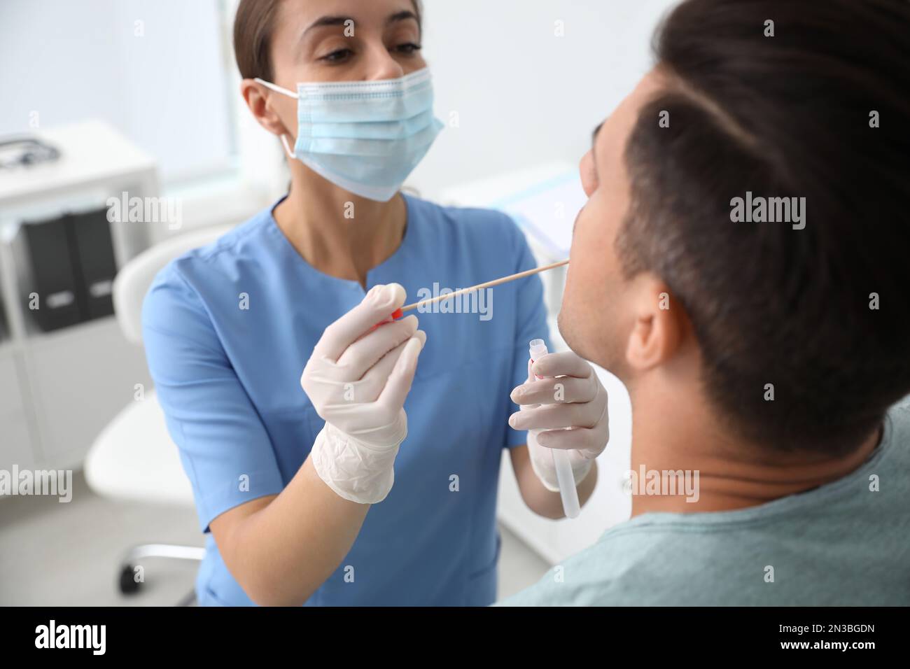 Doctor taking sample for DNA test from man in clinic Stock Photo - Alamy