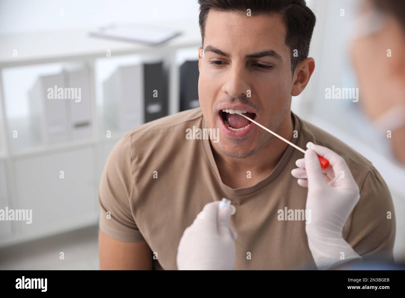 Doctor taking sample for DNA test from man in clinic Stock Photo - Alamy