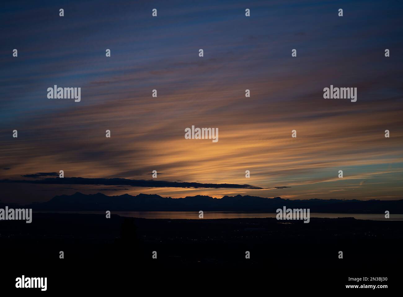The sun sets above the Tordrillo Mountains across Cook Inlet from ...