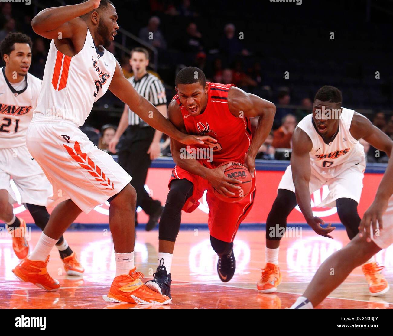 Richmond's Trey Davis, center, drives between Pepperdine's Stacy Davis ...