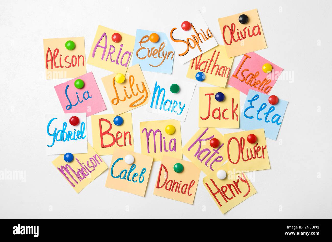Colorful paper sheets with written different baby names on white ...