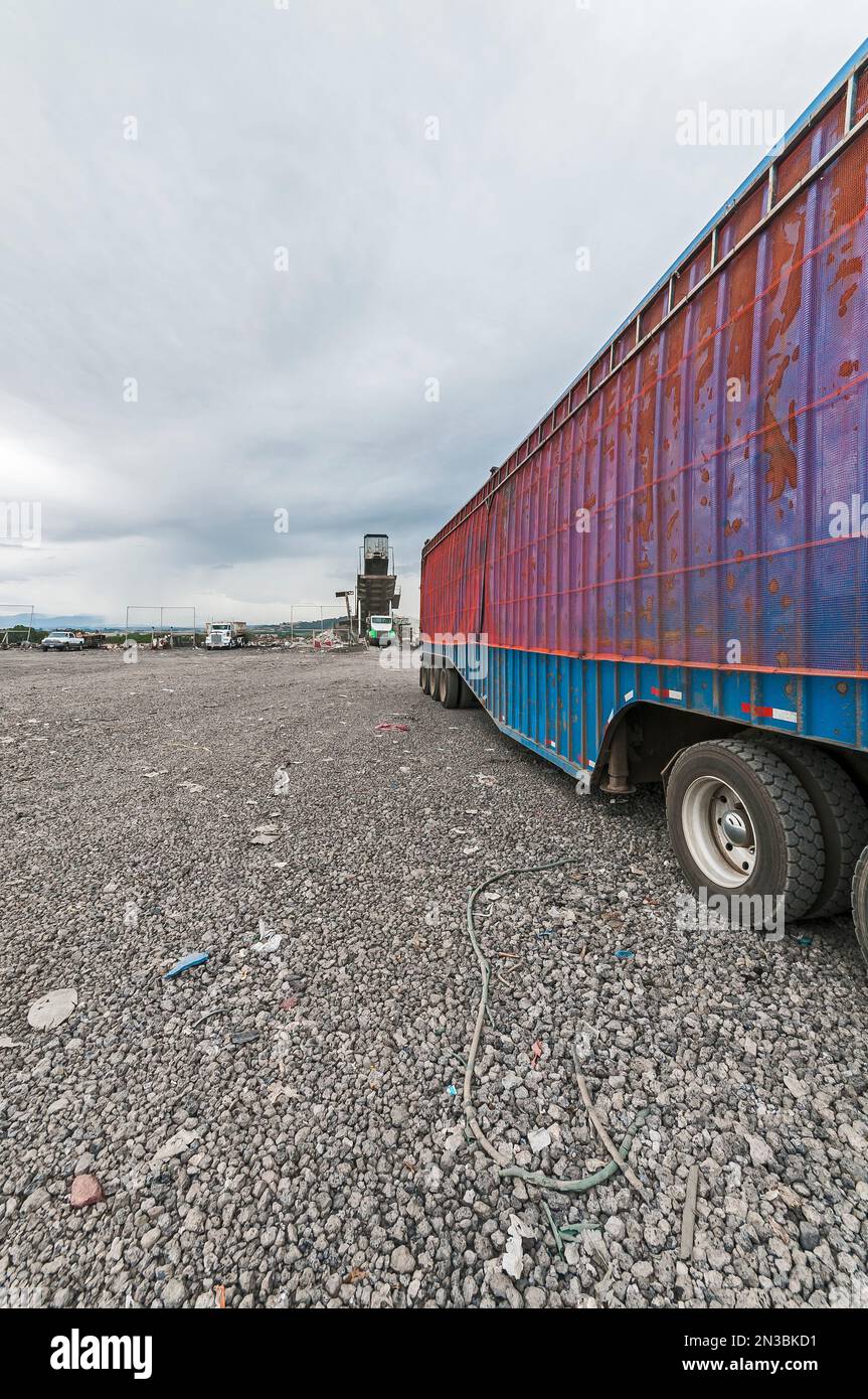 View down the side of a semi-trailer toward a semi-trailer tipper at an ...