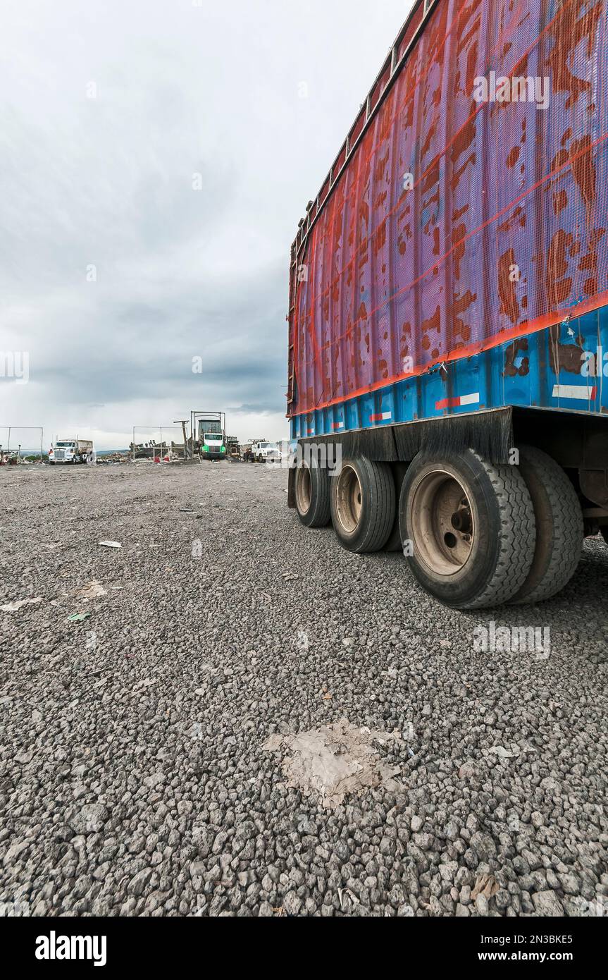View down the side of a semi-trailer toward a semi-trailer tipper at an ...