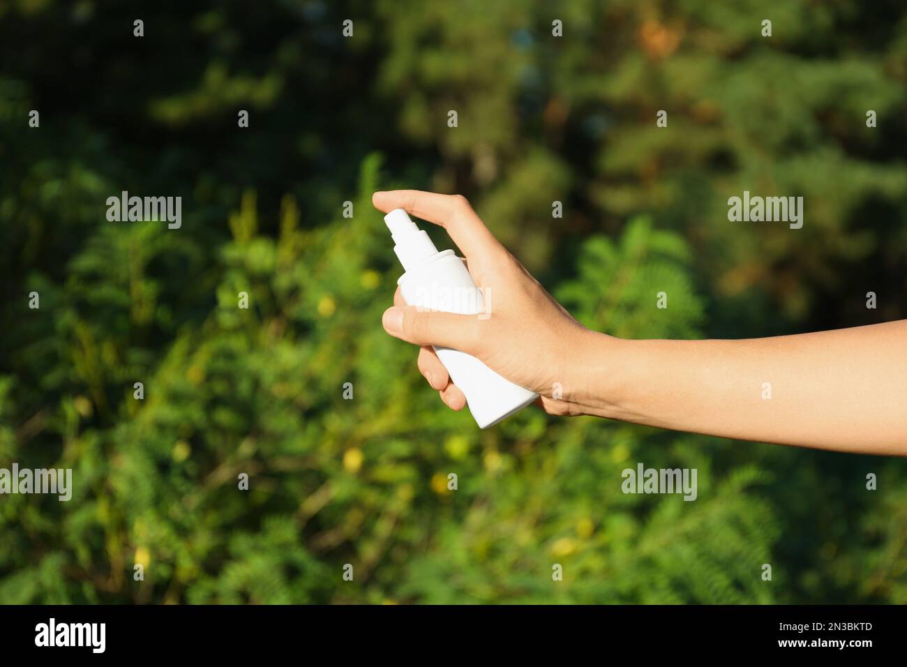 Woman holding insect repellent outdoors, closeup view Stock Photo - Alamy