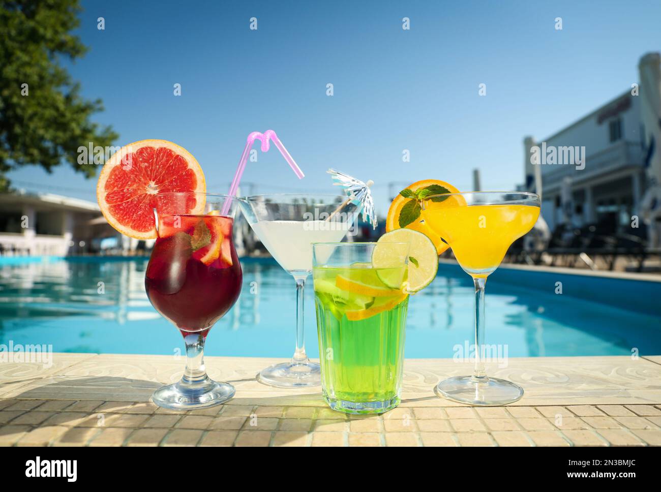 Tasty refreshing cocktails on edge of swimming pool. Party drinks Stock ...