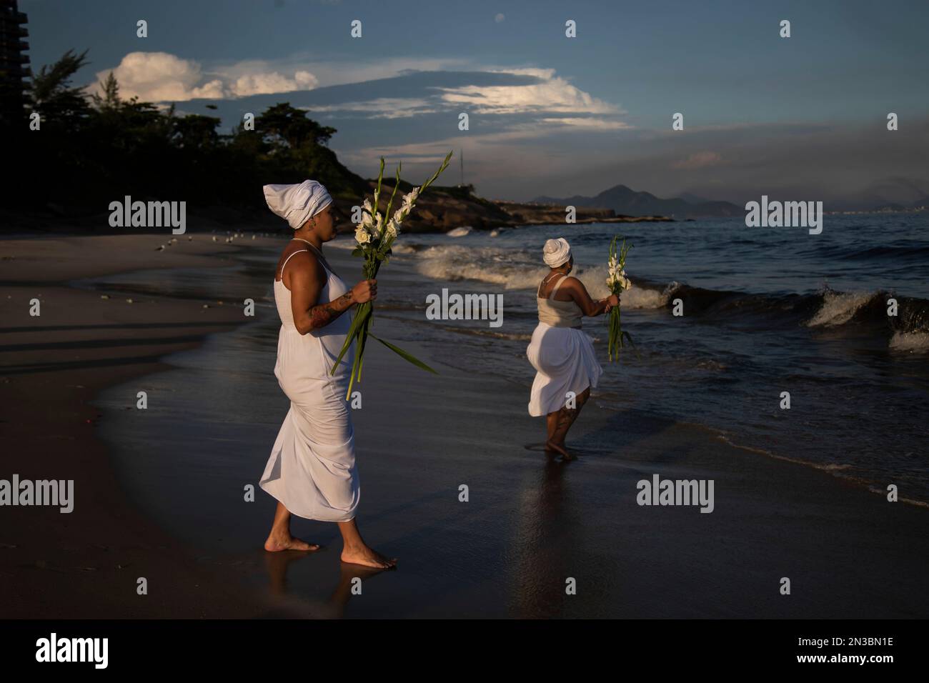 Devotees of the sea goddess Yemanja place flowers offerings for her in ...