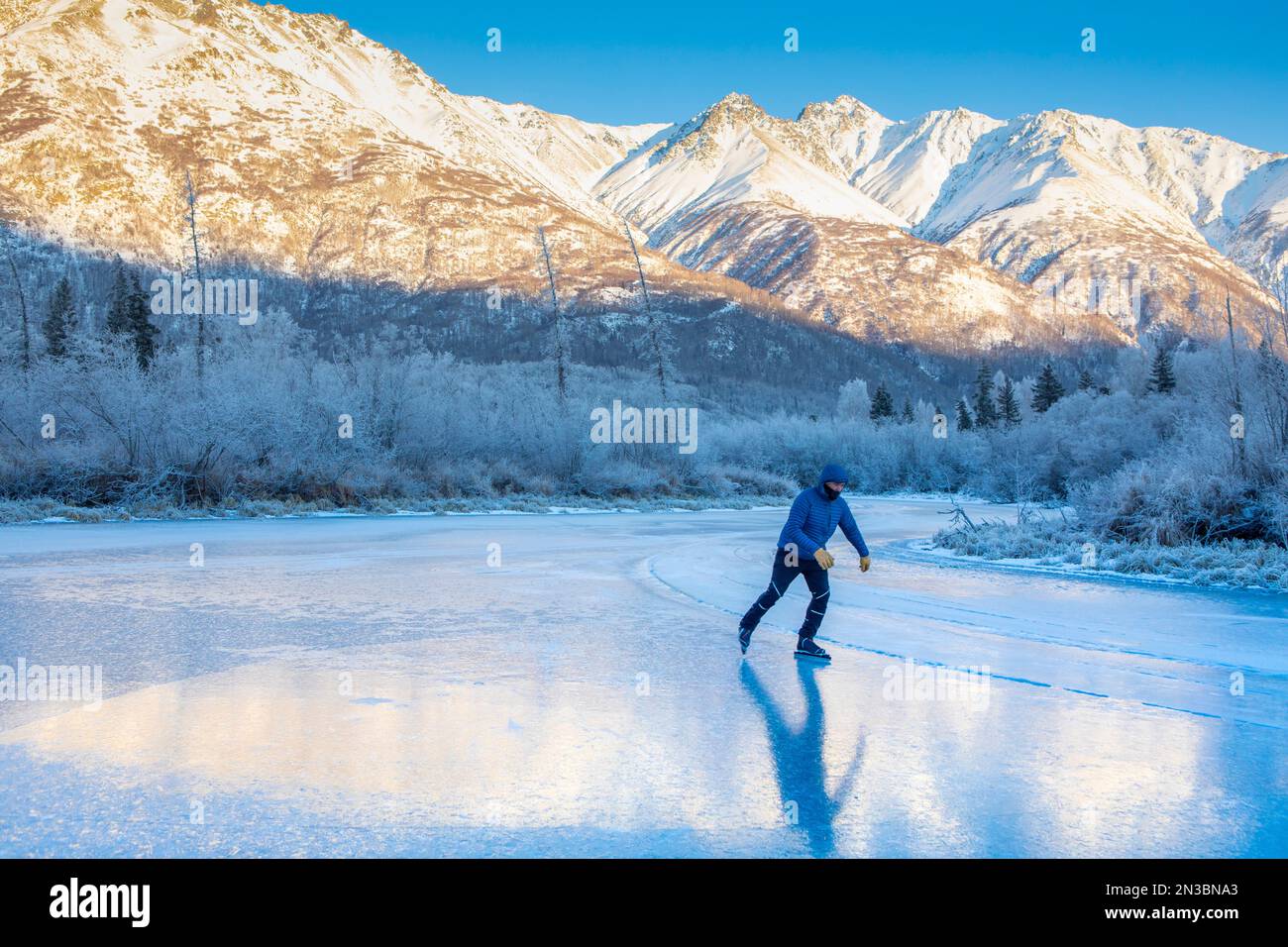 A caucasian man backcountry ice skating, nordic blading, in winter, on ...