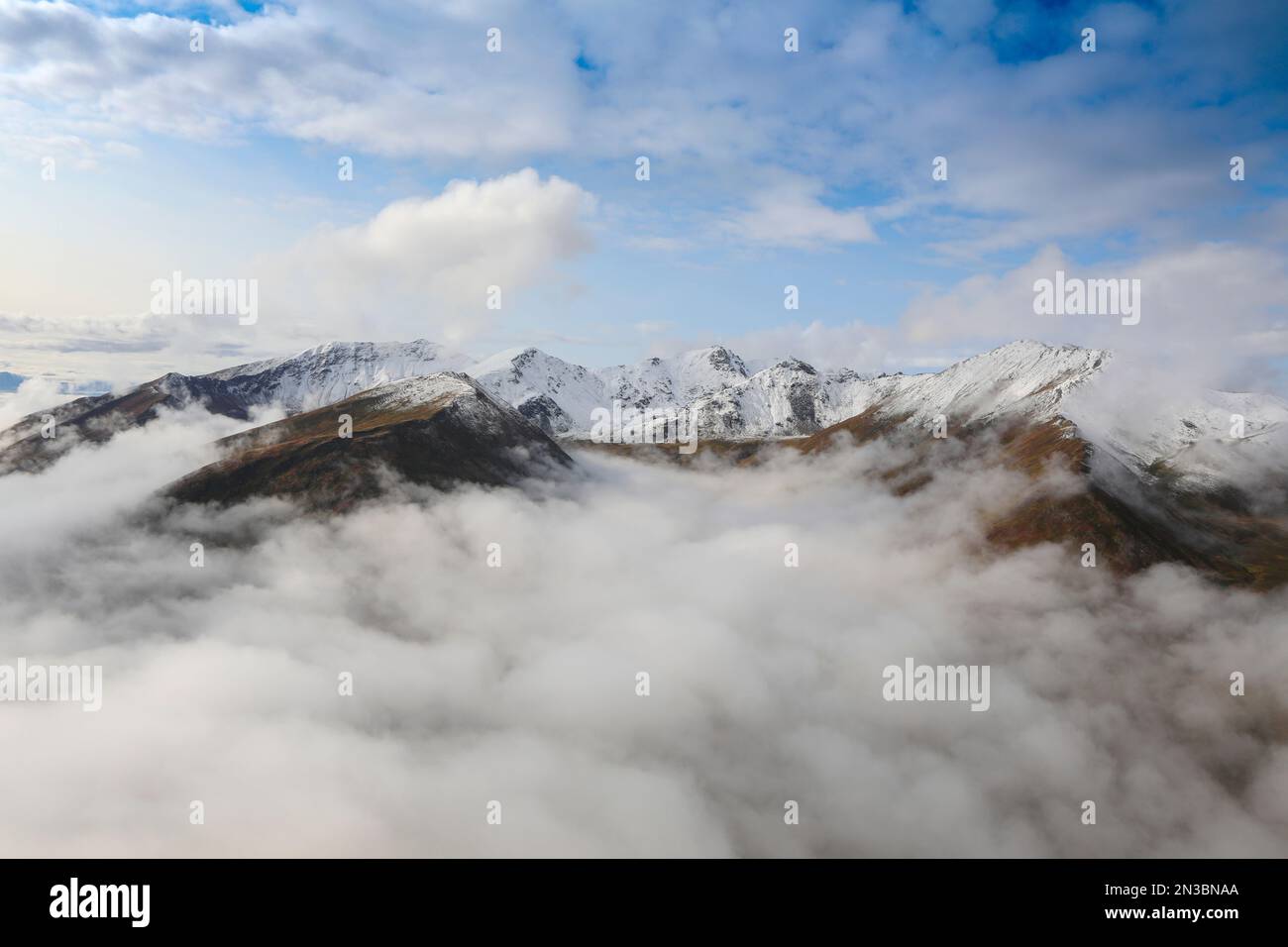 Clouds below and above the ridgeline create islands of mountains with ...