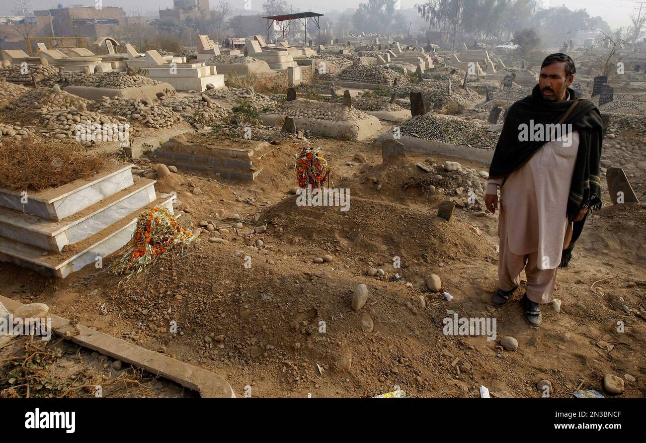 Pakistani gravedigger Taj Muhammad walks around at the Rahman Baba ...