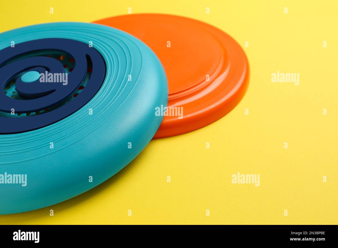 Plastic frisbee disks on yellow background, closeup Stock Photo - Alamy