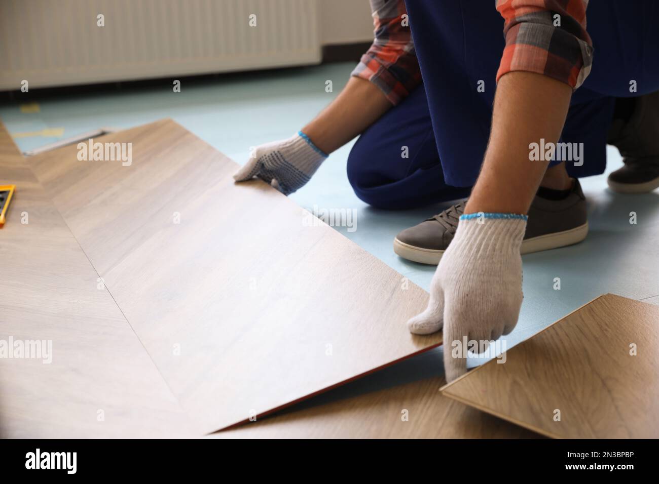 Worker installing laminated wooden floor indoors, closeup Stock Photo ...