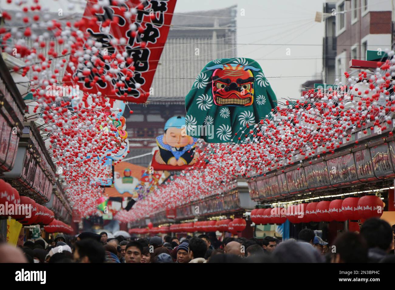 Tourists pack a shopping alley, decorated for coming new year with ...