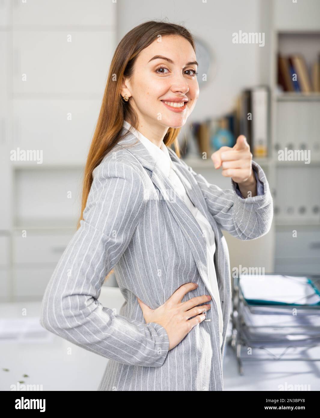 Business woman standing in office and pointing Stock Photo - Alamy