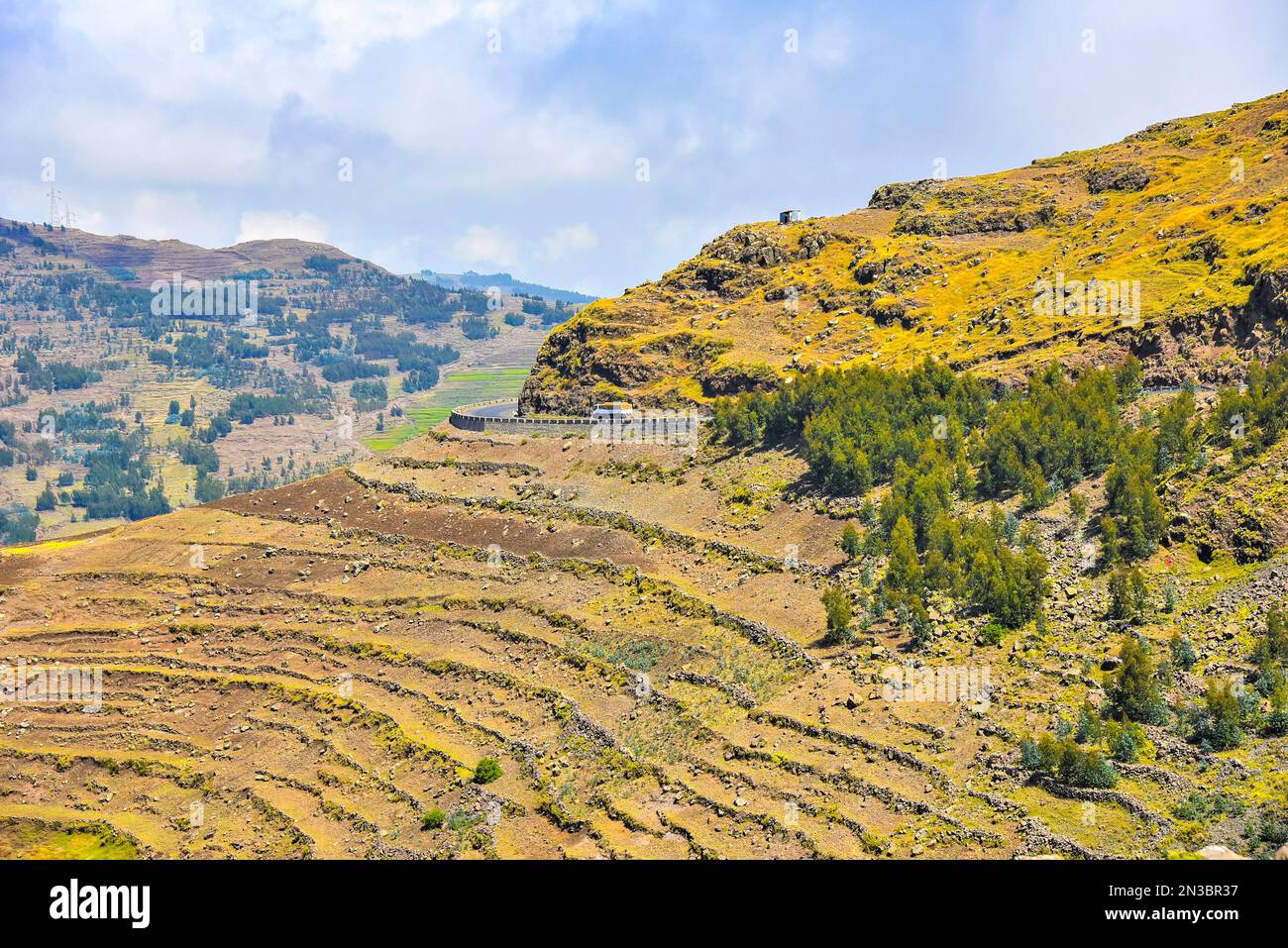 Rural scene on a terraced hillside with a truck traveling along a ...