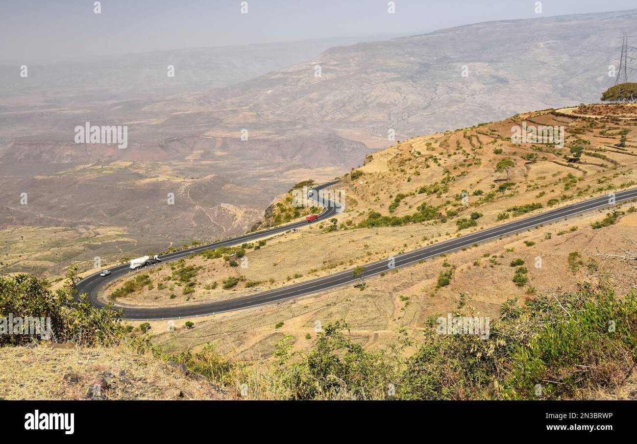 Rural scene on a terraced hillside with trucks traveling along a ...