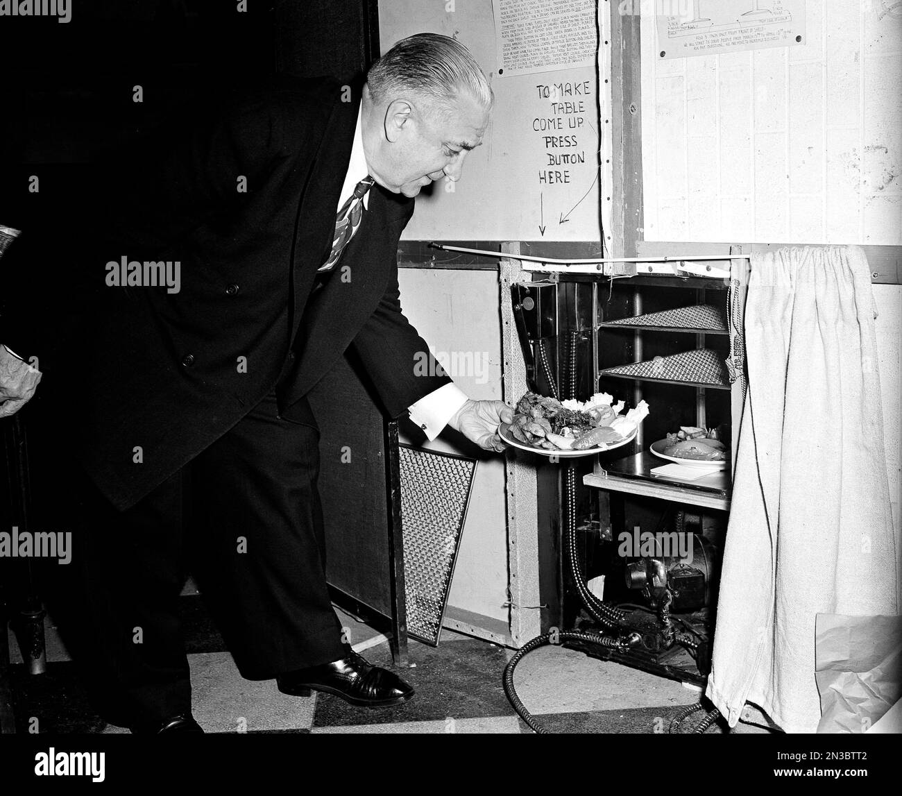 Inventor of the mechanical serving table, John Bellion Daschner, places ...