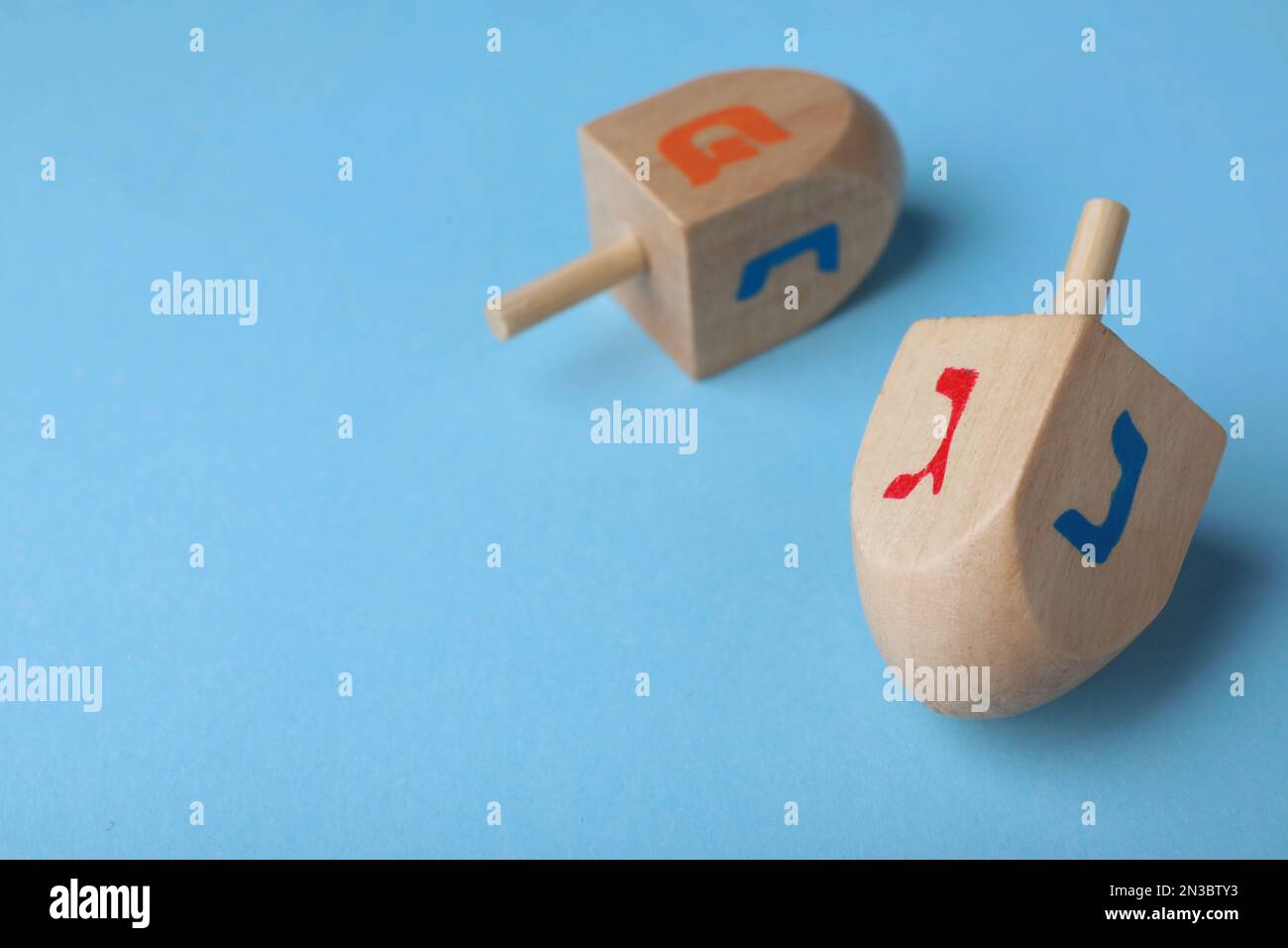 Hanukkah traditional dreidels with letters Gimel, Nun and Pe on light ...