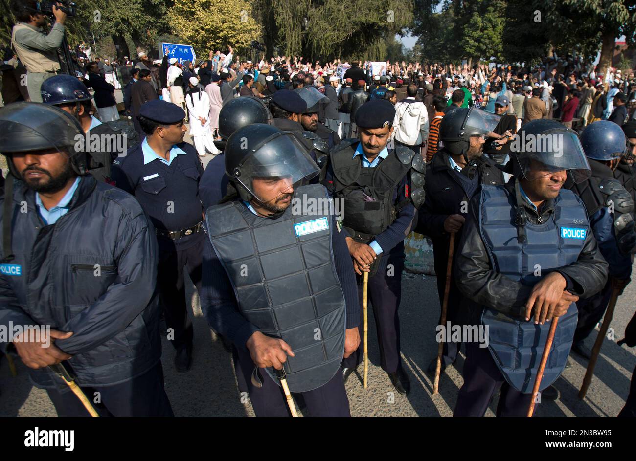 Police officers stand guard as supporters of Pakistani religious party ...