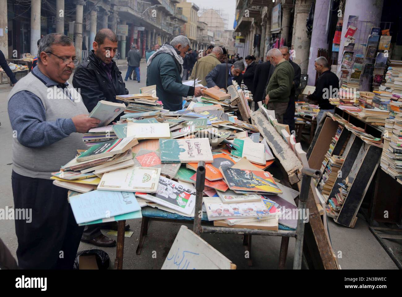 Iraqi men look at books on al-Mutanabi Street, home to the city's book ...