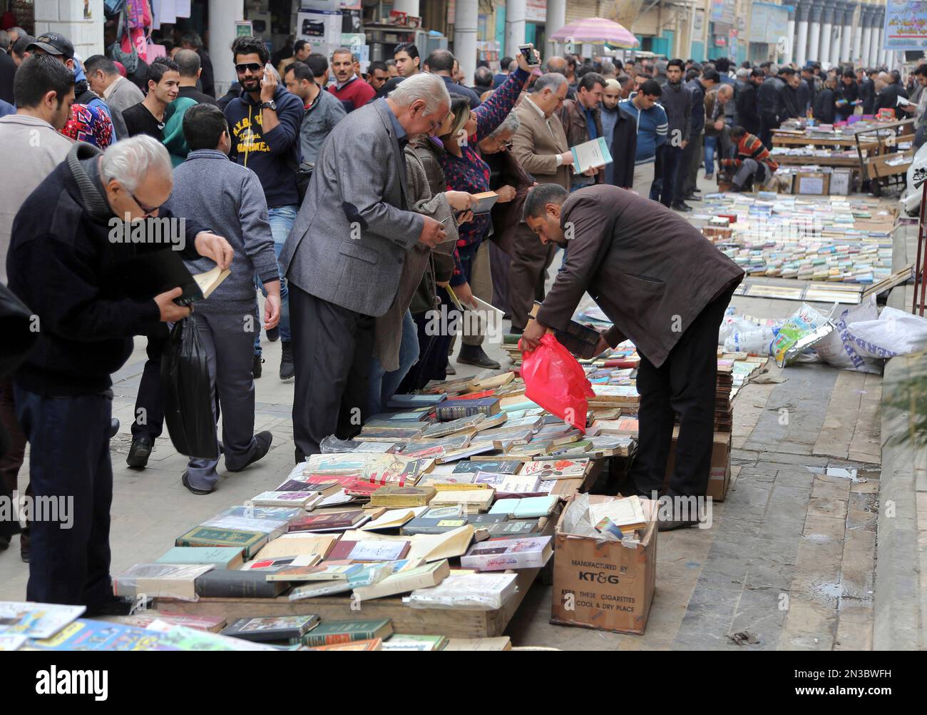 Iraqi men look at books on al-Mutanabi Street, home to the city's book ...