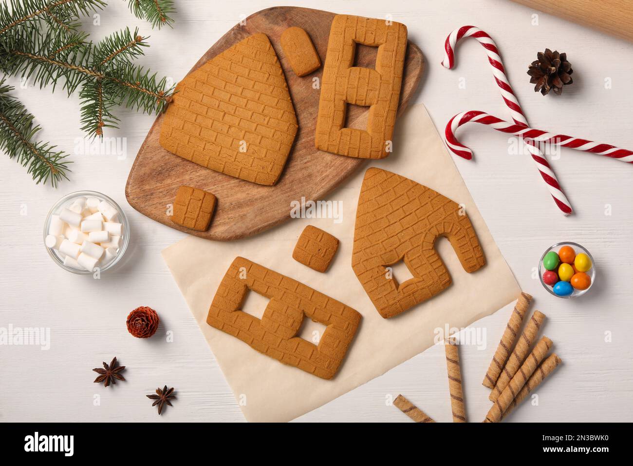 Parts of gingerbread house, ingredients and fir tree branch on white ...