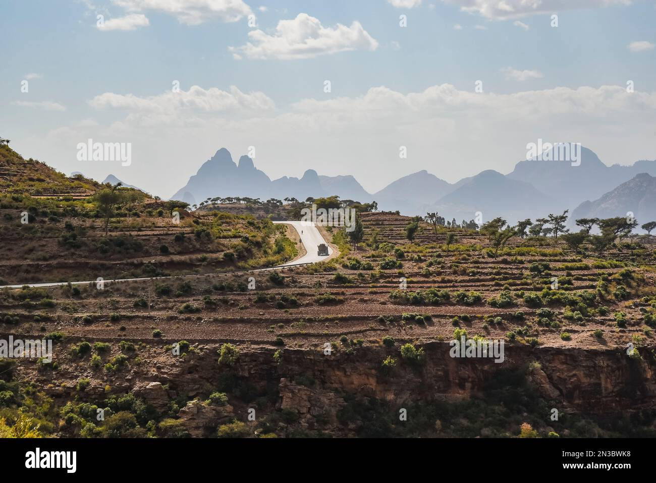 Rural scene with terraced farmland and a truck traveling along a ...