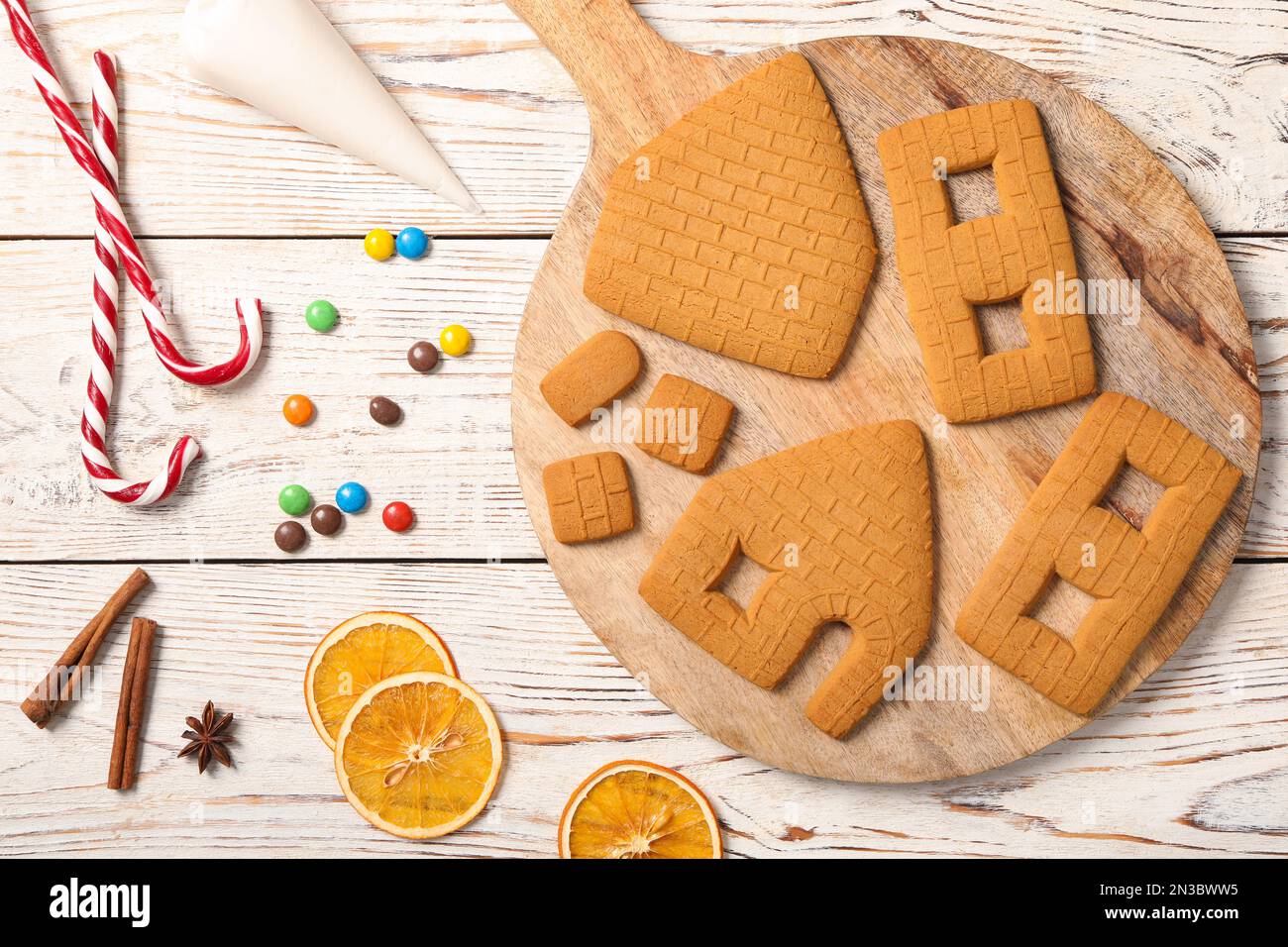 Parts of gingerbread house and ingredients for decoration on white ...