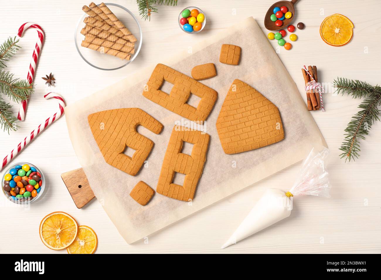 Parts of gingerbread house and ingredients for decoration on white ...