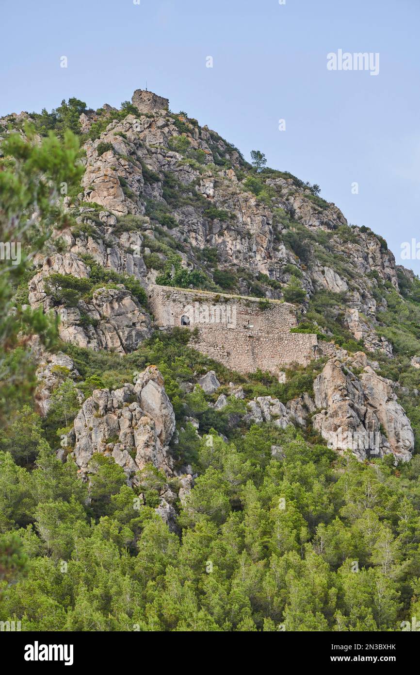 Old, stone built structure in the cliffs on a mountainside in morning ...