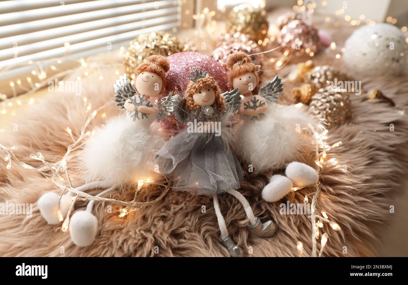 Beautiful angel dolls and shiny bauble on window sill indoors Stock ...