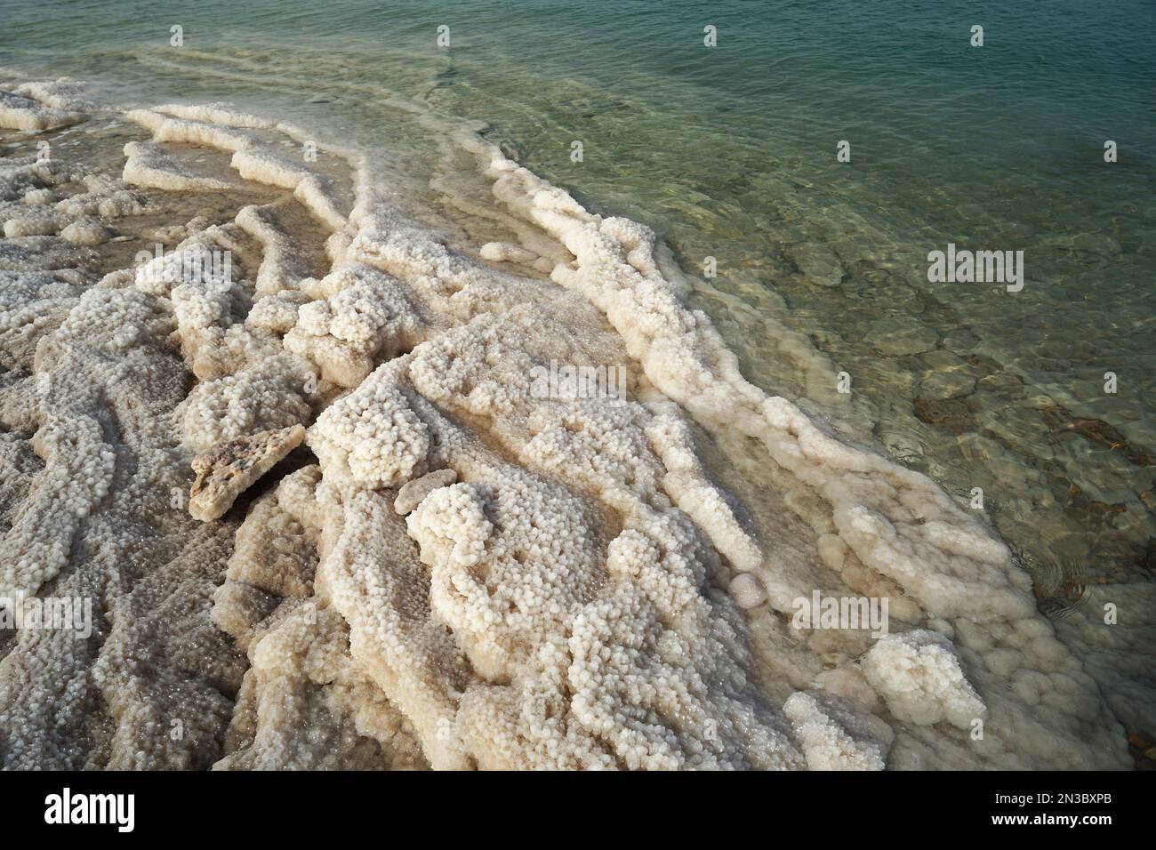 Dead Sea panoramic view with piles of mineral salt and clear water ...