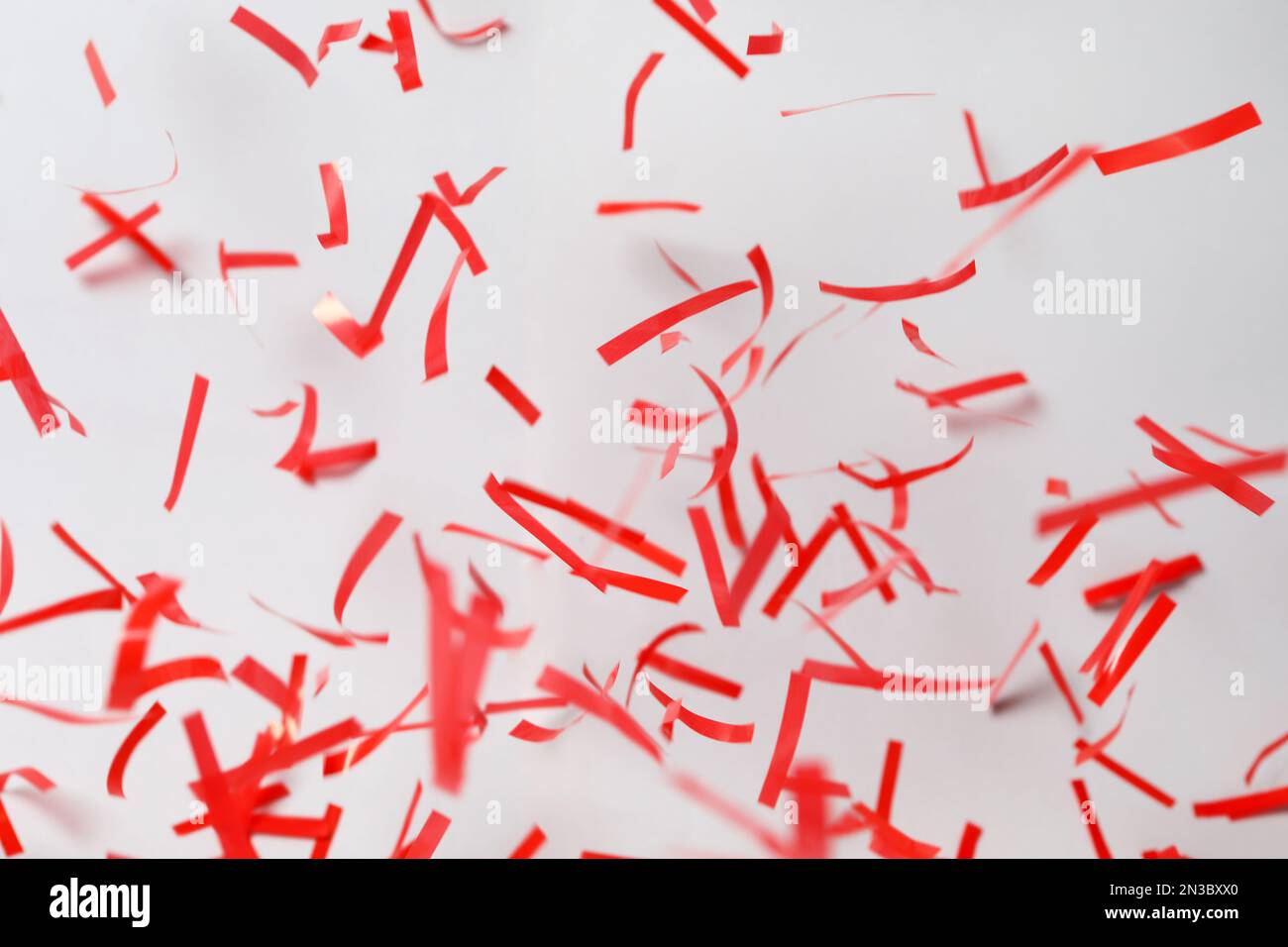 Shiny red confetti falling down on light grey background Stock Photo ...