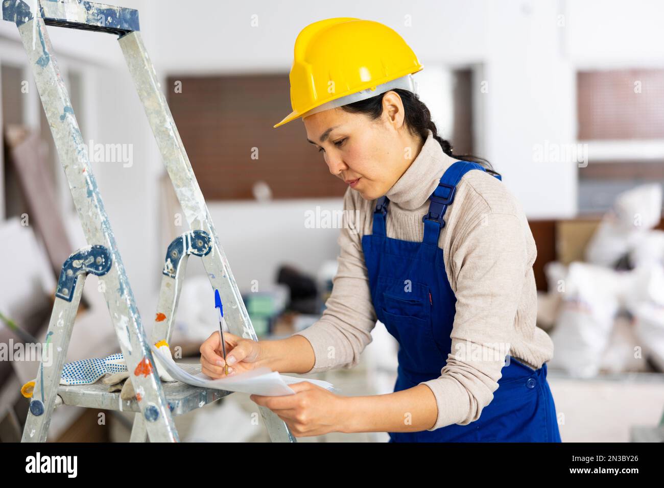 Female engineer writing in check list during repair works Stock Photo ...