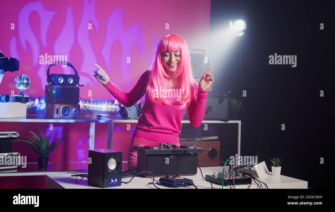 Cheerful dj performing electronic music during concert in nightclub ...