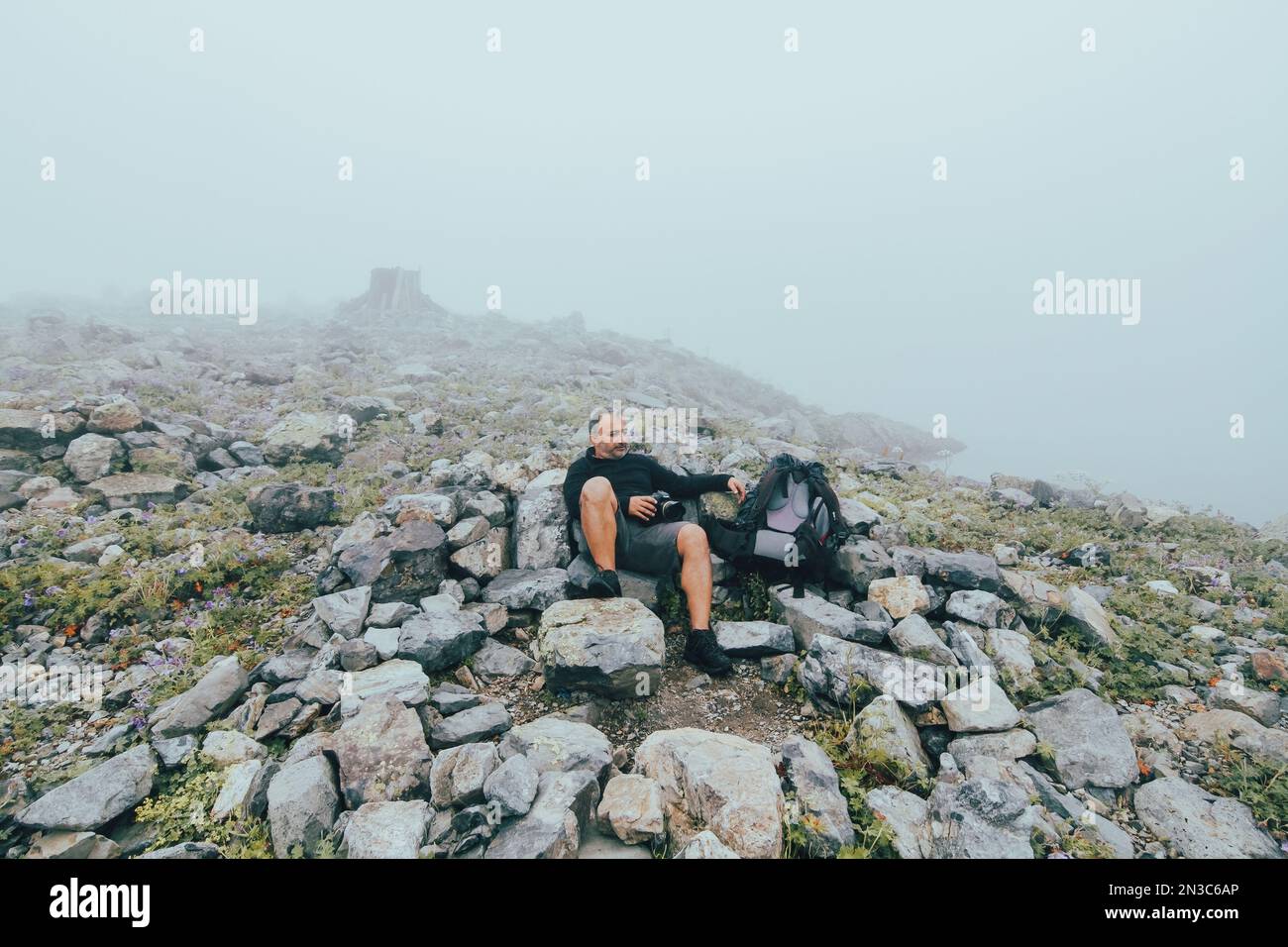 Hiker taking a break during mountain climbing Stock Photo - Alamy