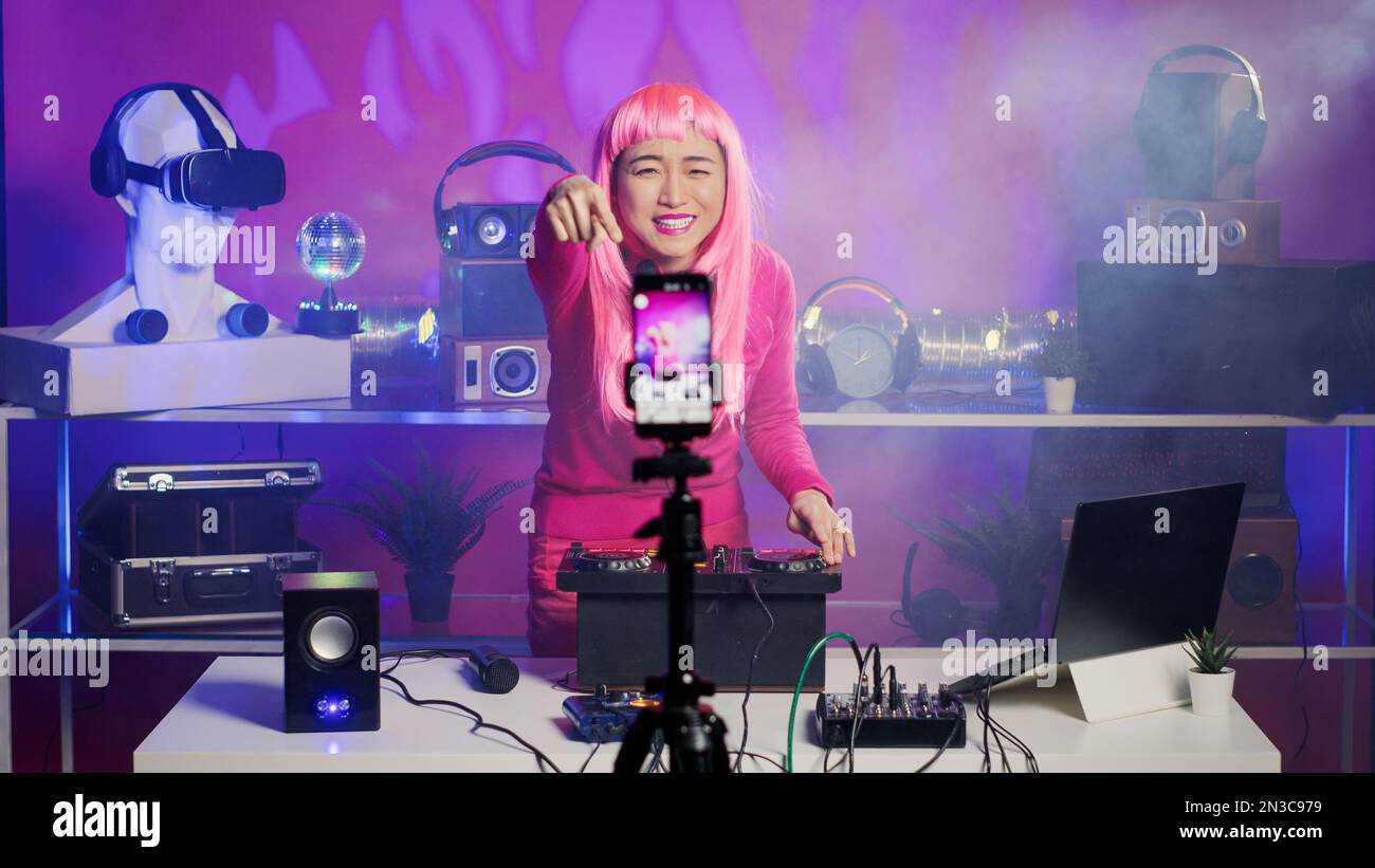 Dj performing electronic song at mixer filming process with mobile ...