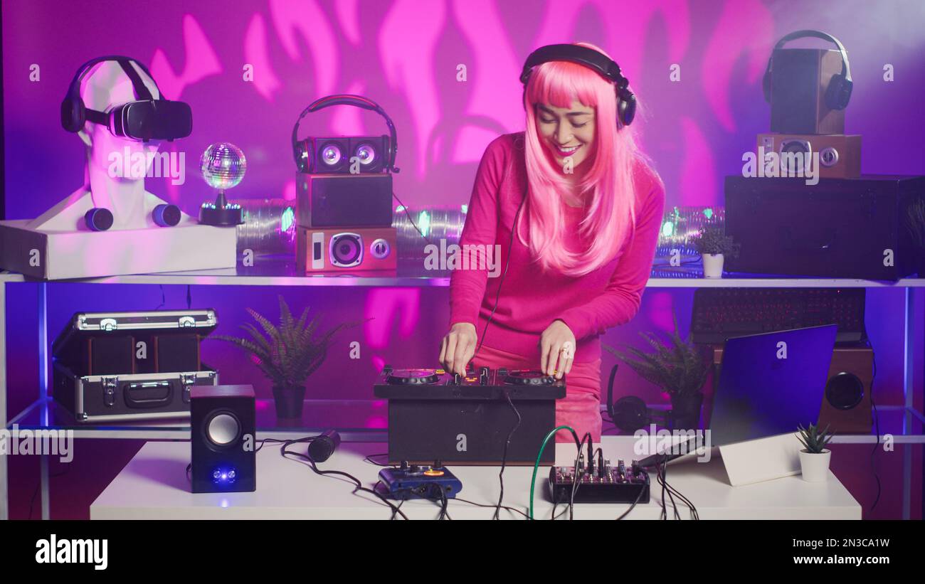 Musician with headset standing at dj table having fun while mixing ...